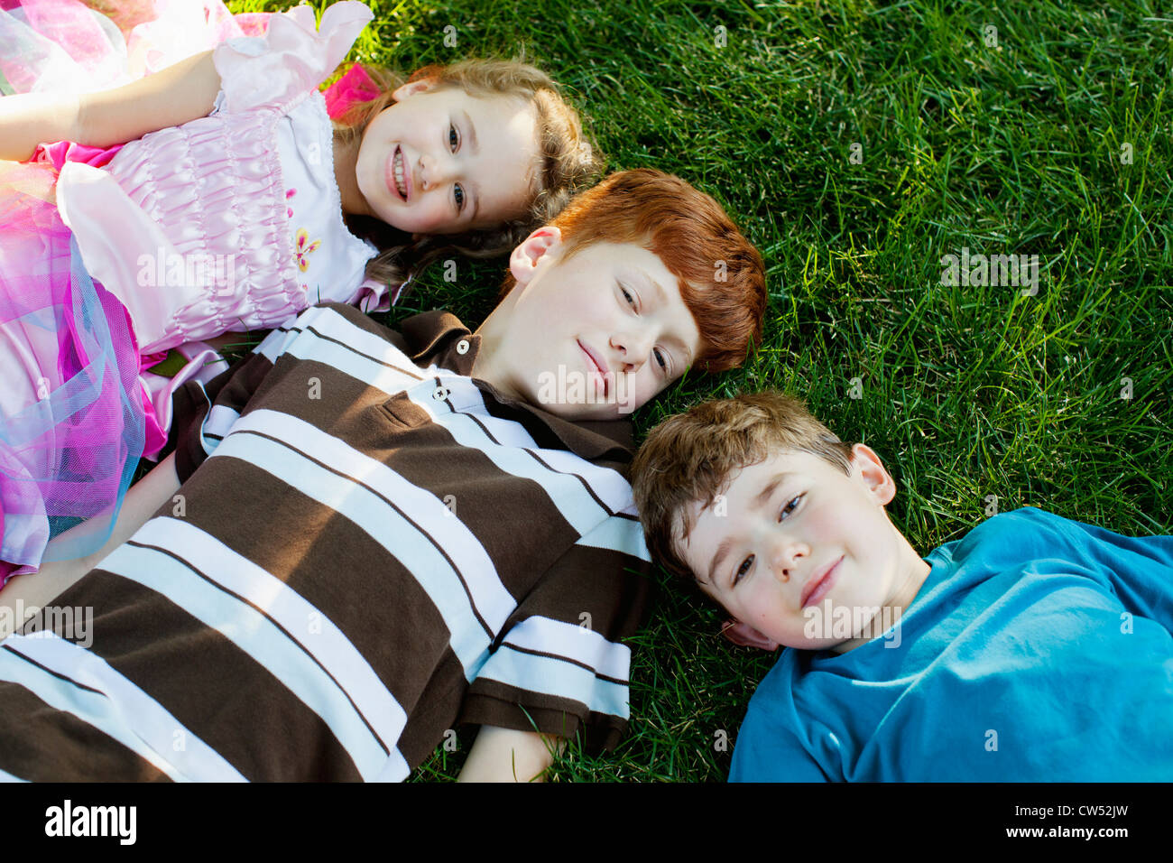 Kids laying in grass Stock Photo - Alamy