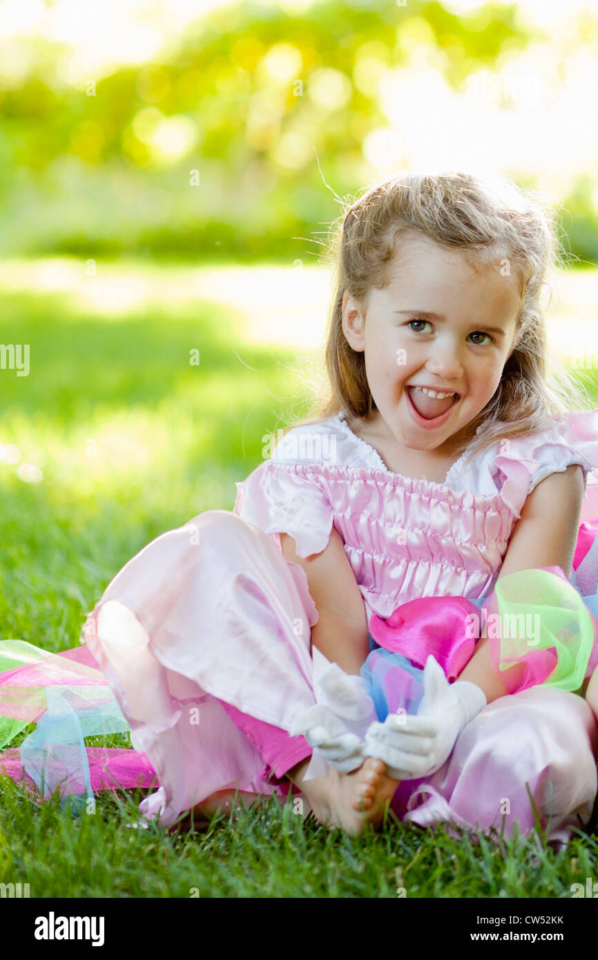 Laughing girl sitting in grass Stock Photo - Alamy