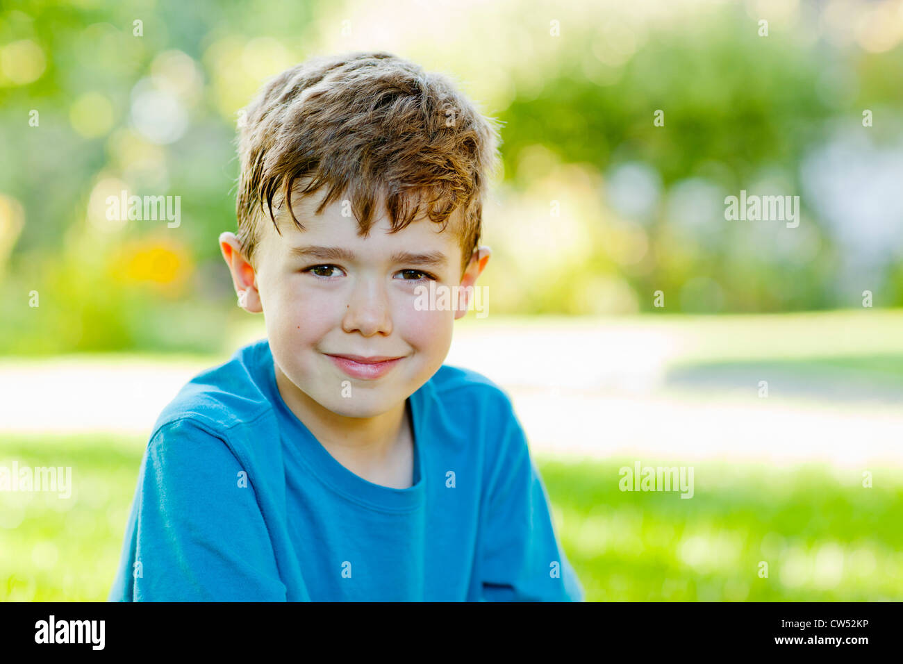 Boy sitting in grass Stock Photo - Alamy