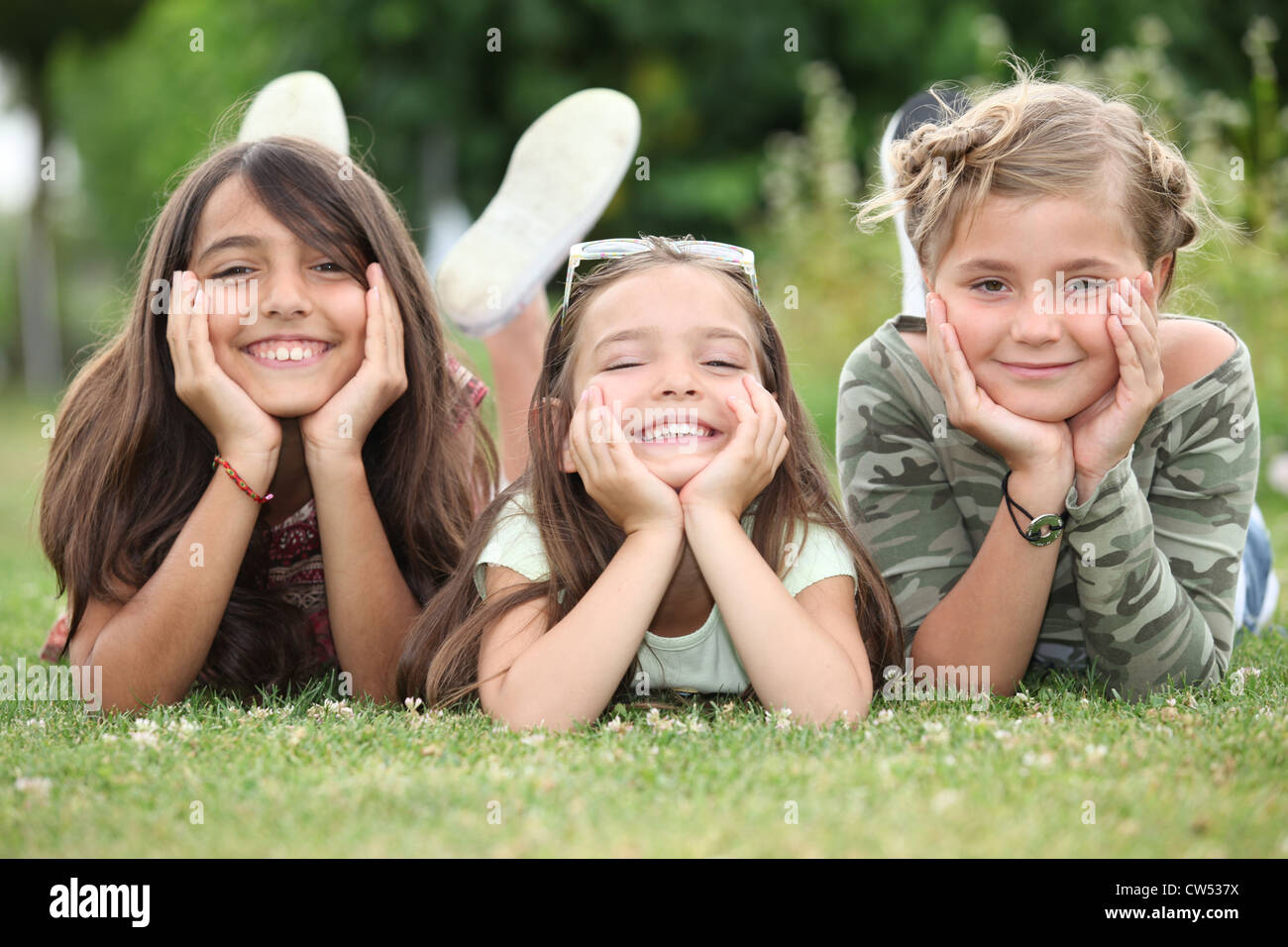 Girls lying on grass Stock Photo - Alamy