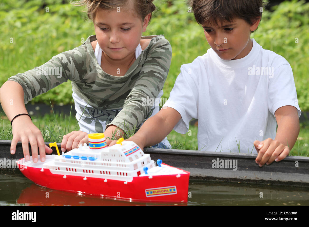 Children playing with boat Stock Photo - Alamy