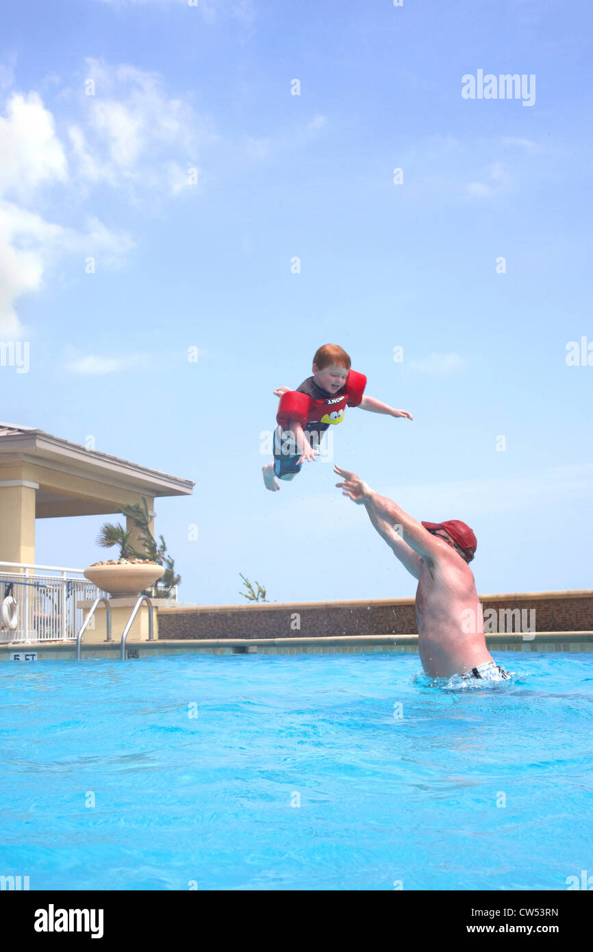 Father throwing son swimming in outdoor pool Stock Photo - Alamy