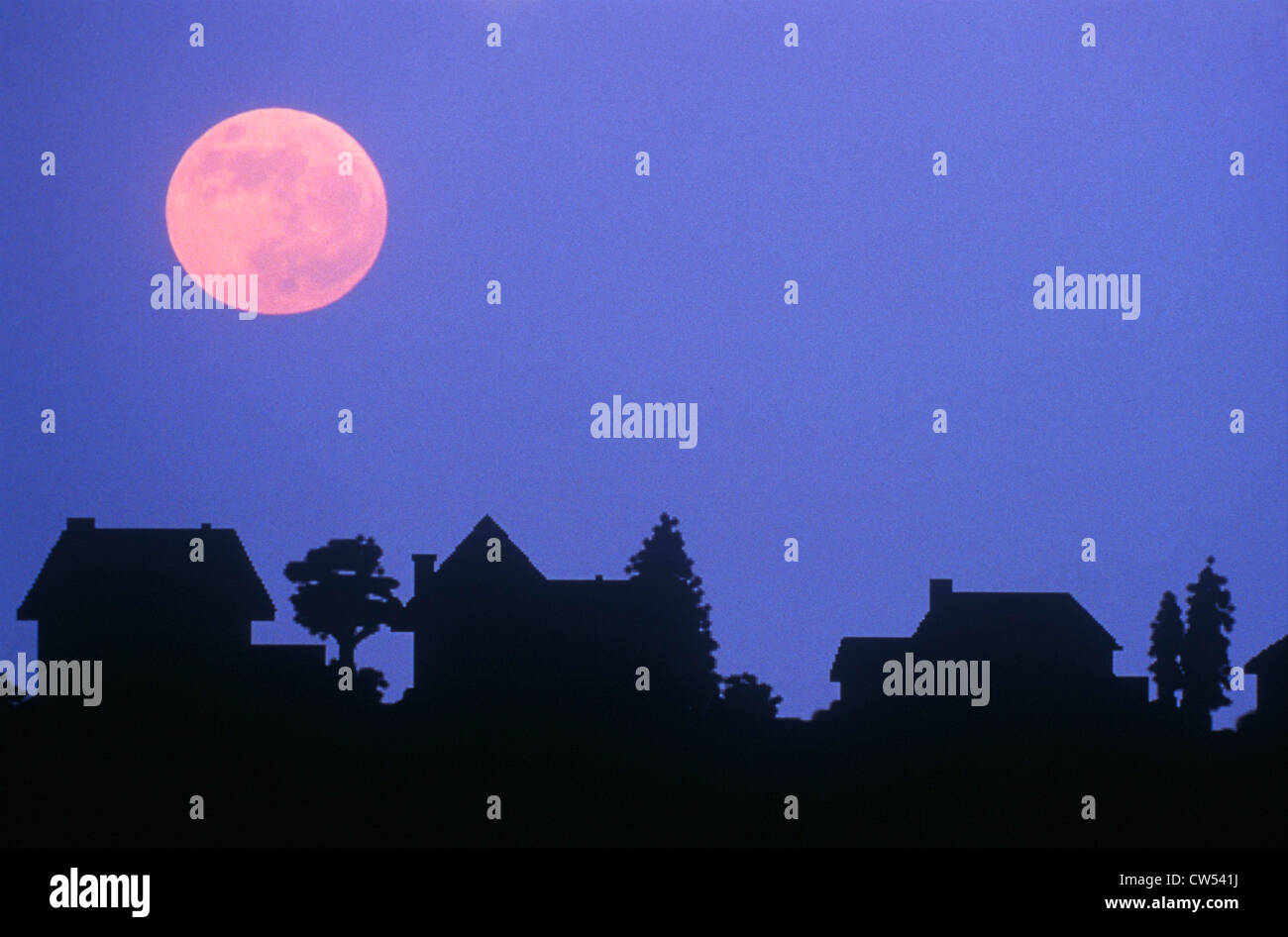 Silhouette of full moon over family homes in typical neighborhood Stock ...