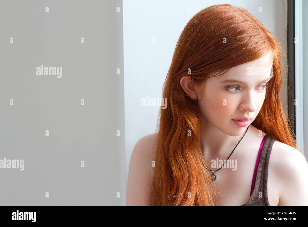 USA, New York City, Manhattan, Portrait of girl looking out window ...