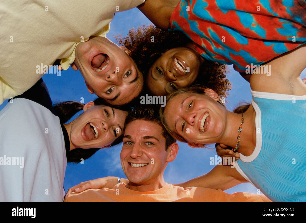 Portrait of young men and young women smiling in a huddle Stock Photo ...