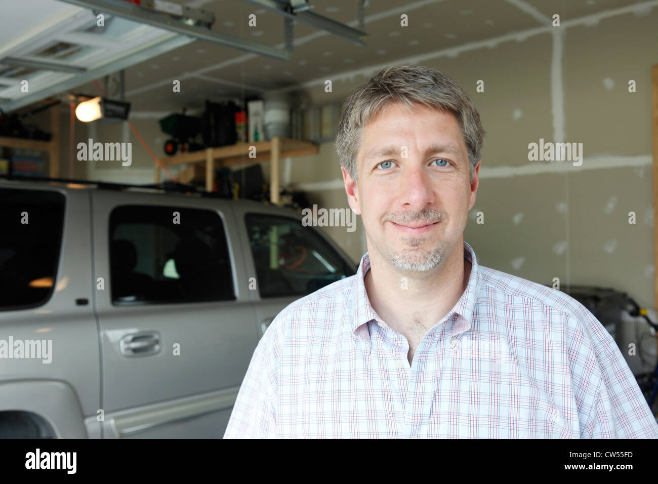 Portrait of smiling man in garage Stock Photo - Alamy