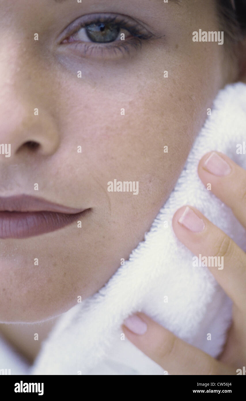 Close-up of a young woman wiping her face with a towel Stock Photo - Alamy