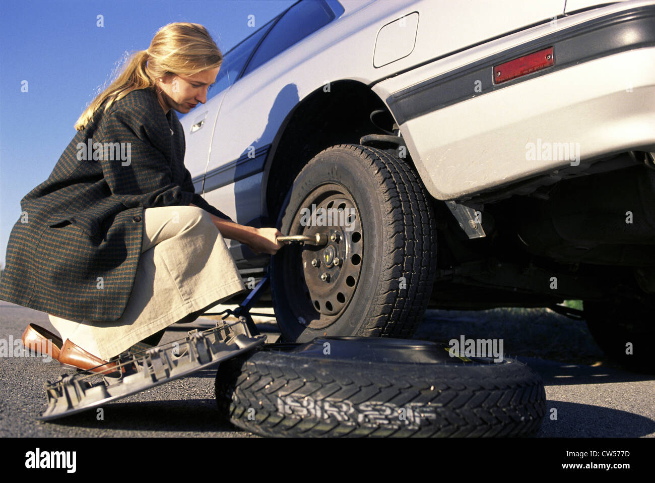 Person changing flat tire hi-res stock photography and images - Alamy