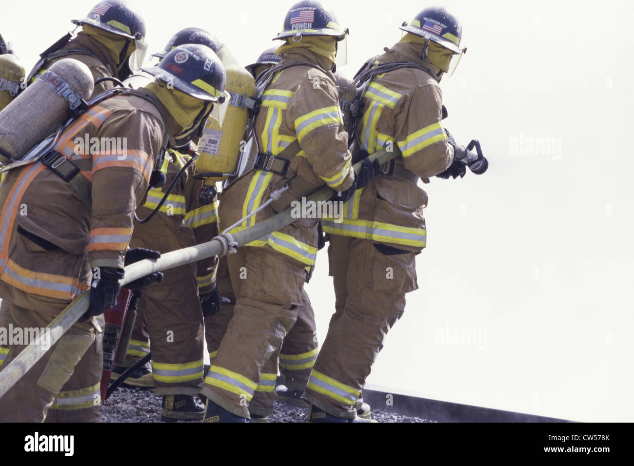 Side profile of a group of firefighters holding water hoses Stock Photo ...