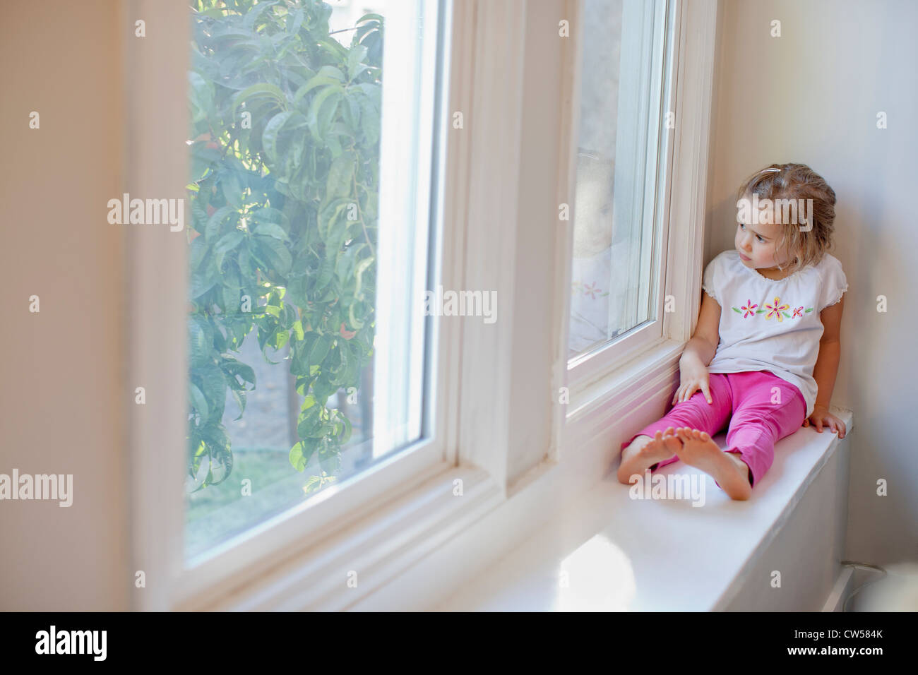 Girl looking out window Stock Photo - Alamy