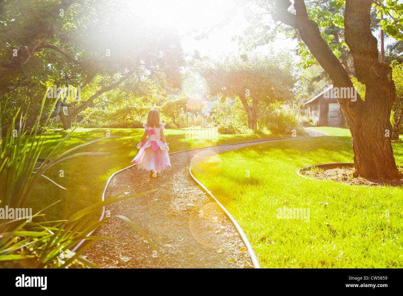 Girl in princess outfit walking on path in sunlight Stock Photo - Alamy