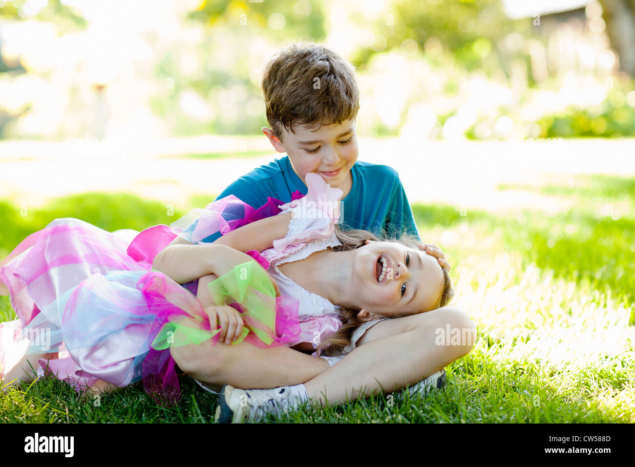 Portrait of brother and sister playing in garden Stock Photo - Alamy