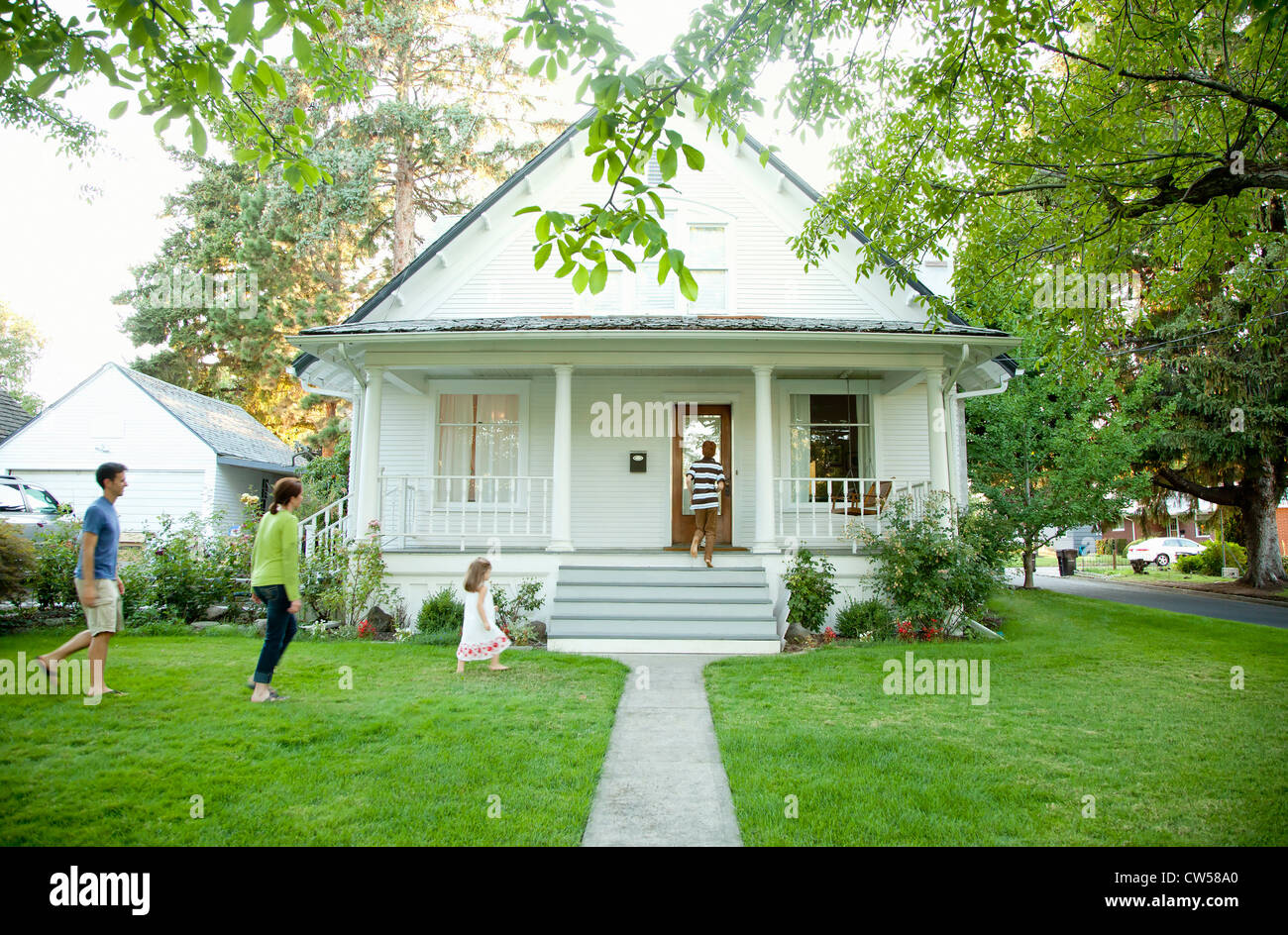 Kids with parents walking into house Stock Photo - Alamy