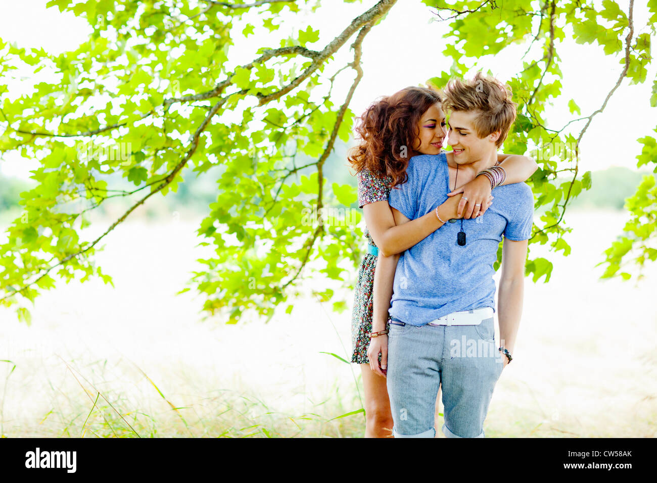 Loving couple standing under tree hi-res stock photography and images ...