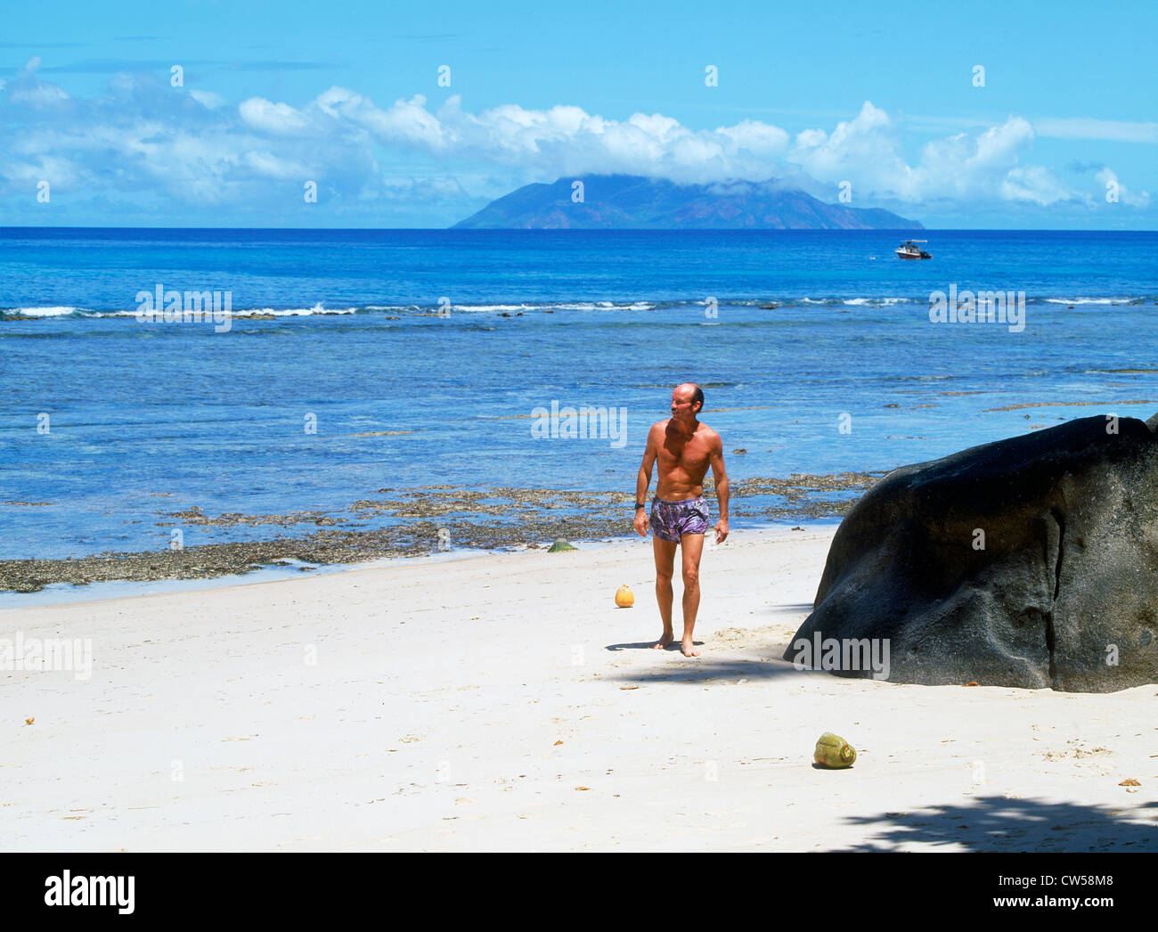 Man walking across white sandy beach on Mahe Island in Seychelles Stock ...
