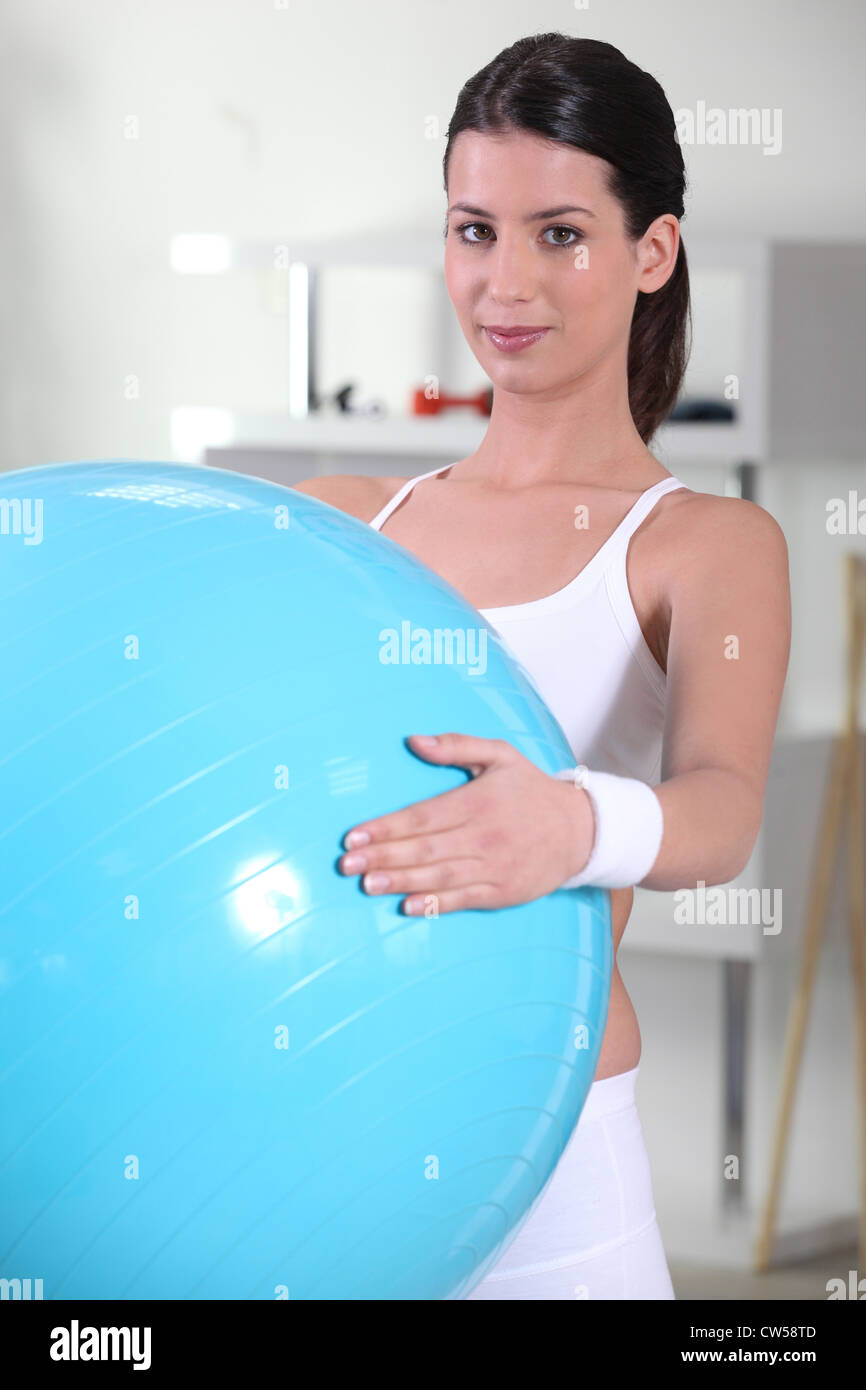 Brunette blue ball in the gym keeping Stock Photo - Alamy