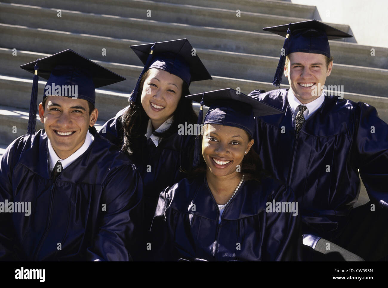 Portrait of a group of young graduates sitting on stairs Stock Photo ...
