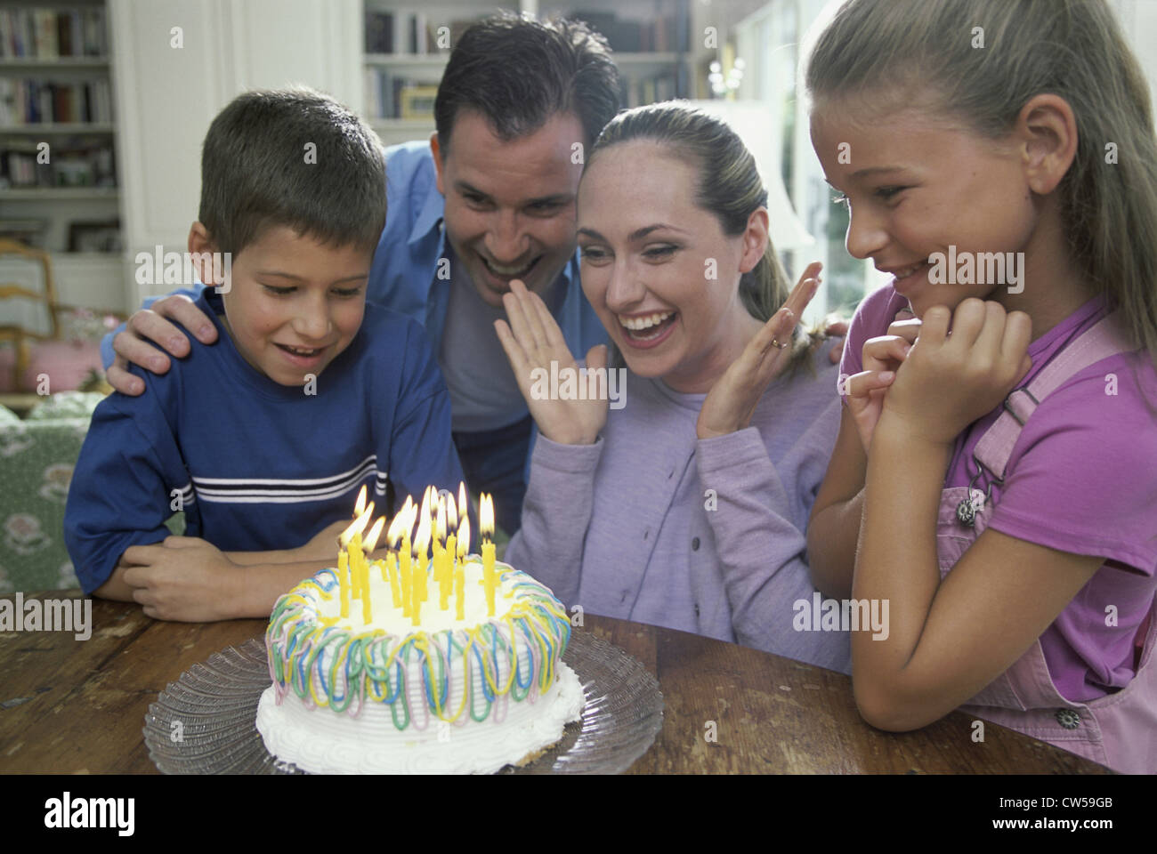 Parents with their son and daughter in front of a birthday cake Stock ...