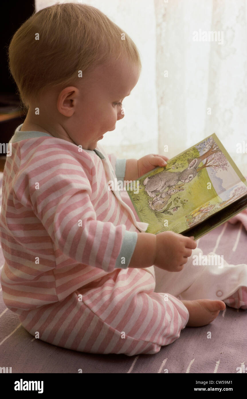 Side profile of a baby reading a book Stock Photo - Alamy