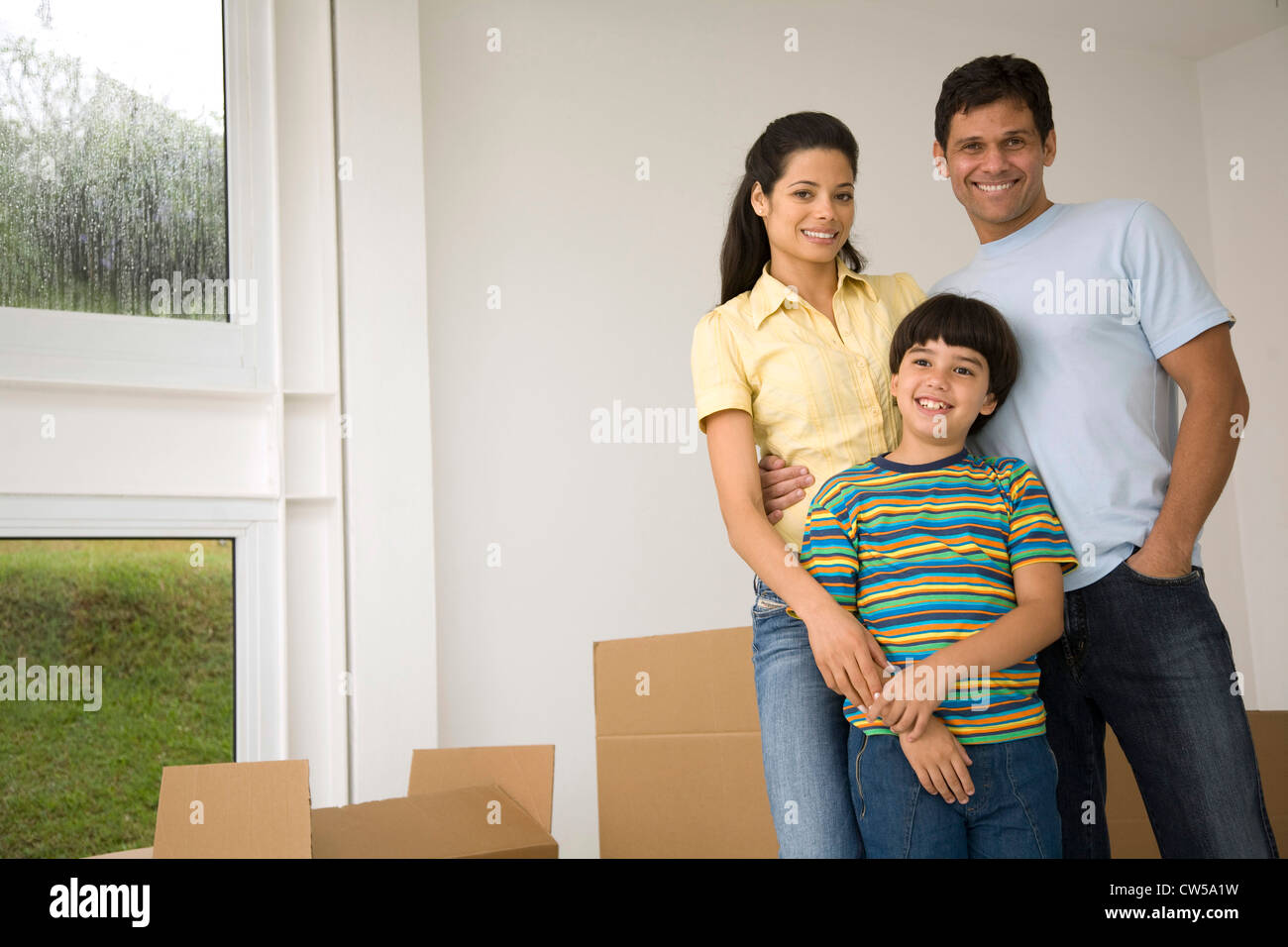 Boy with his parents standing in a room and smiling Stock Photo - Alamy