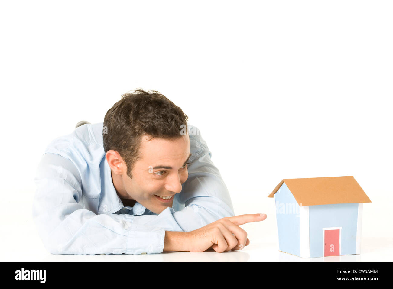 Young man pointing at a model house Stock Photo - Alamy