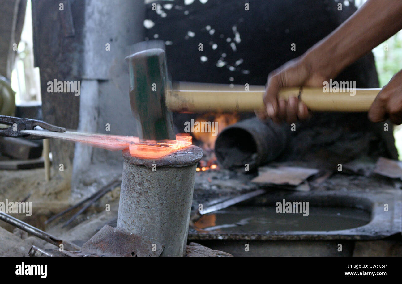 Forging a spade blade glowing in a village smithy Stock Photo - Alamy