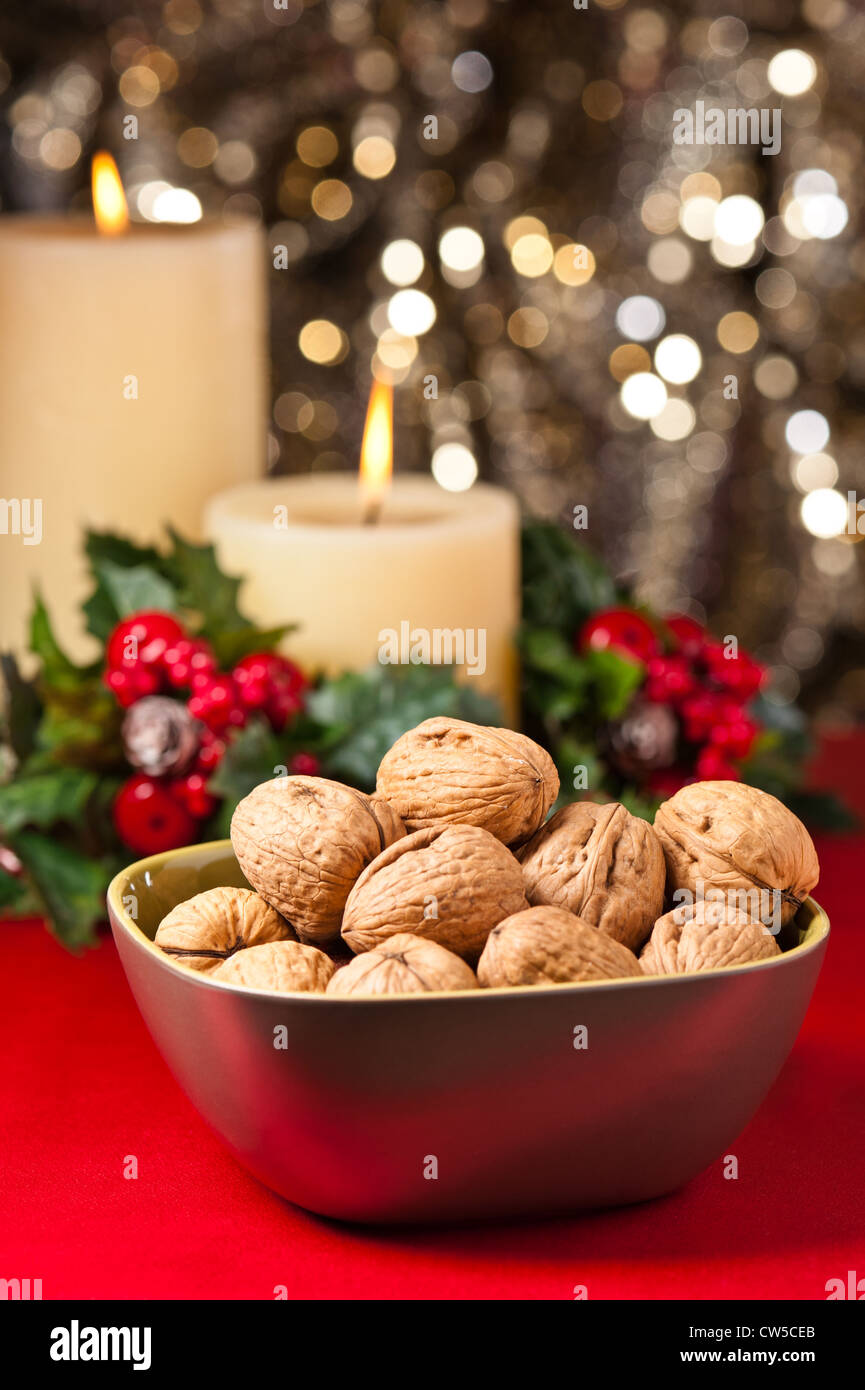 Bowl of walnuts in festive setting in front of a gold glitter ...