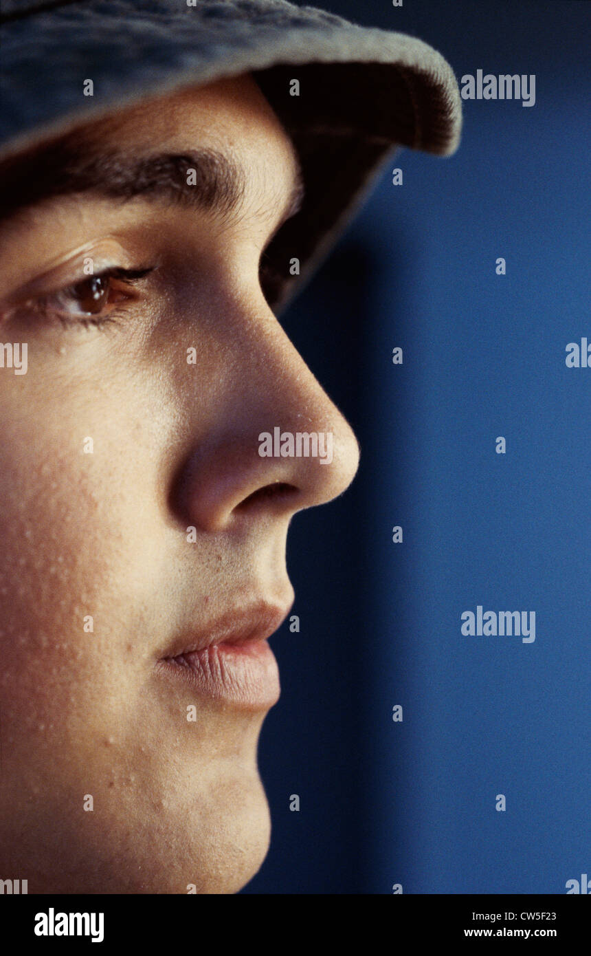 Side profile of a teenage boy wearing a baseball cap Stock Photo - Alamy