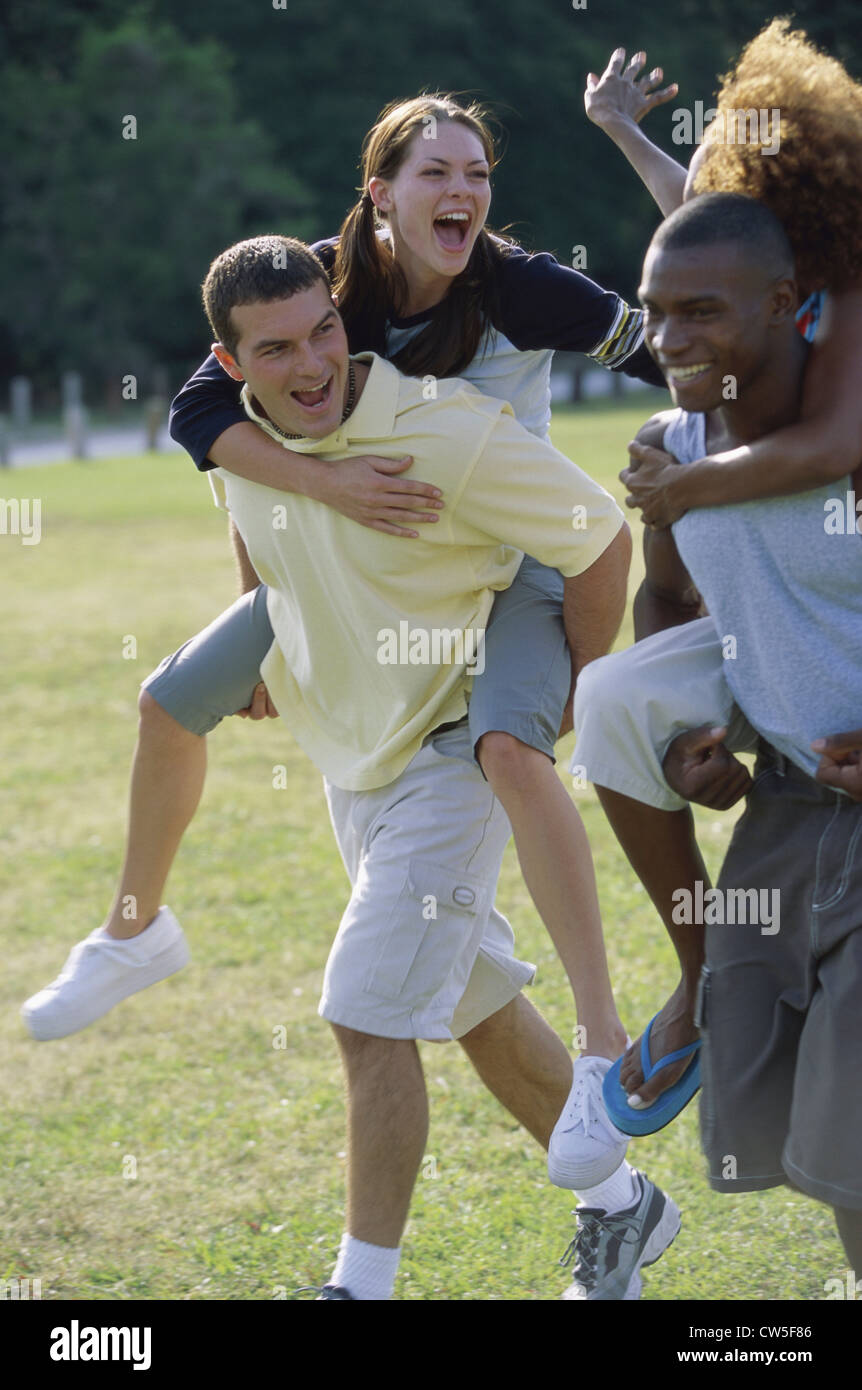 Two young women riding piggyback on two young men Stock Photo - Alamy