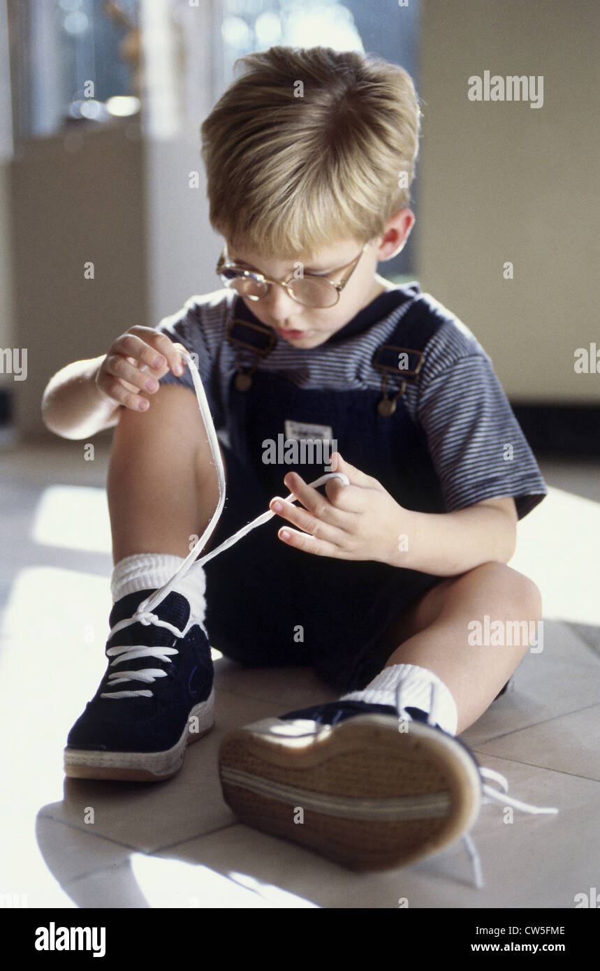 Boy tying his shoelaces hi-res stock photography and images - Alamy
