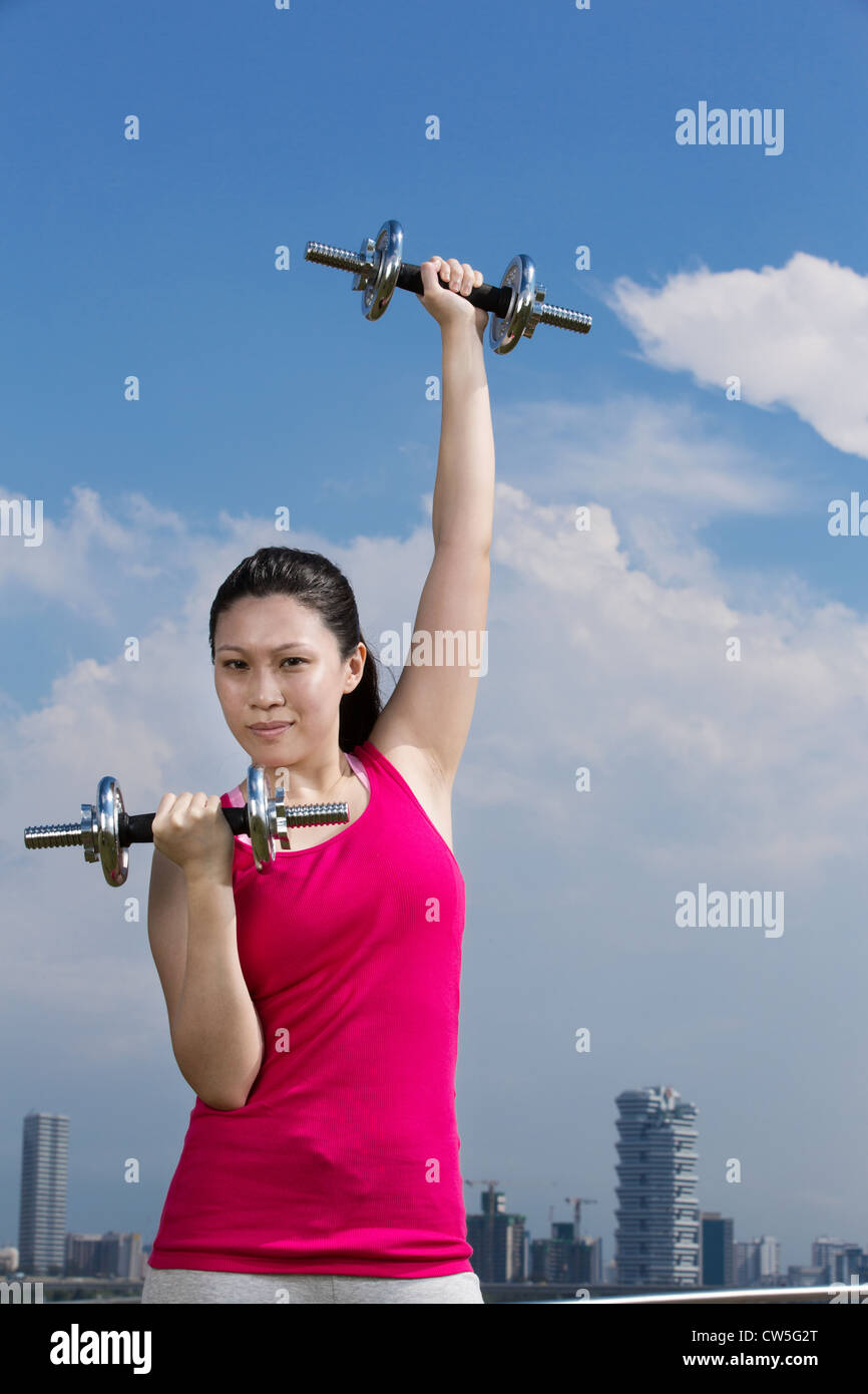 Chinese woman exercising with dumbbells Stock Photo - Alamy