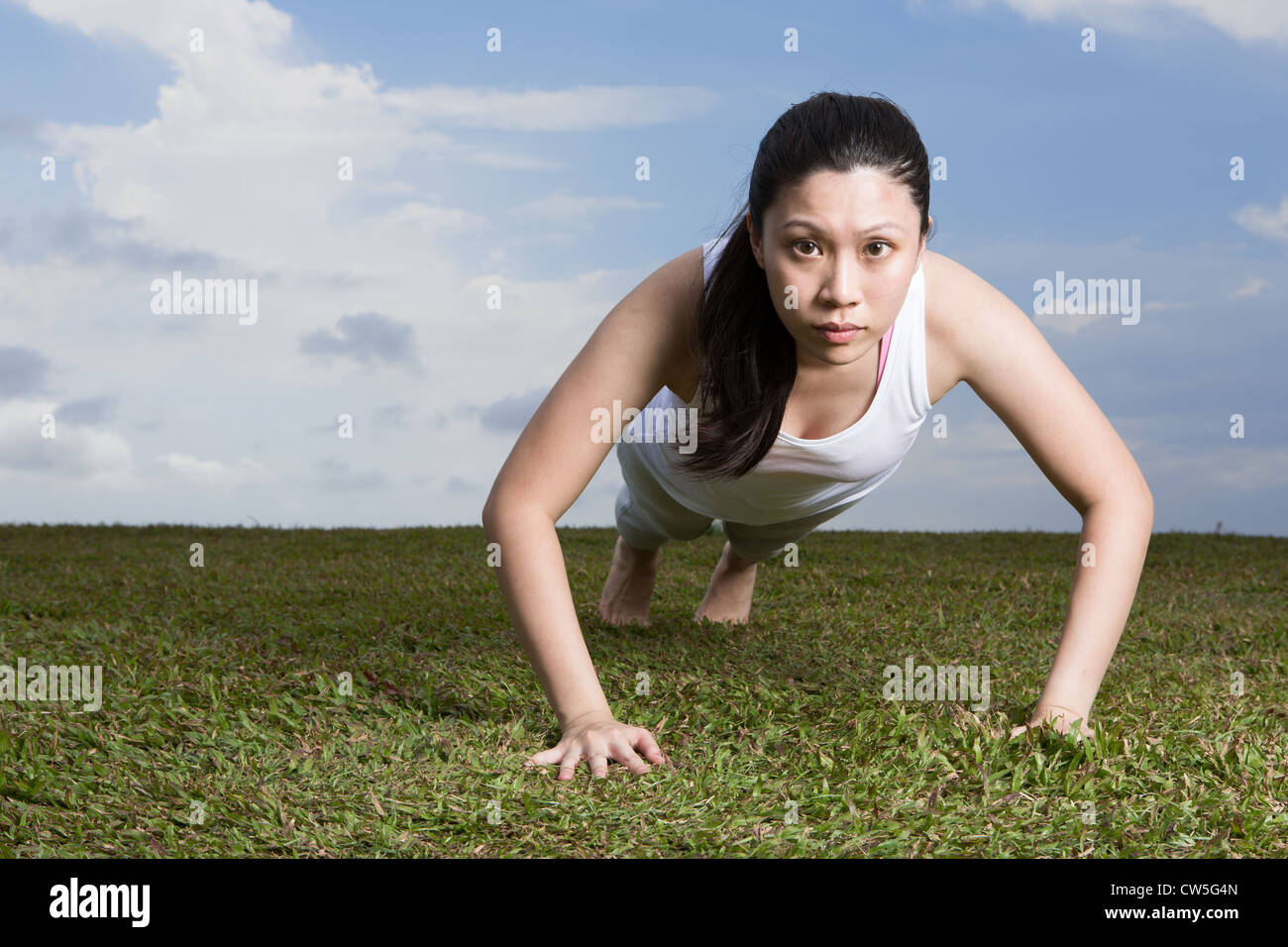 Fit Chinese woman doing push-ups at the park Stock Photo - Alamy