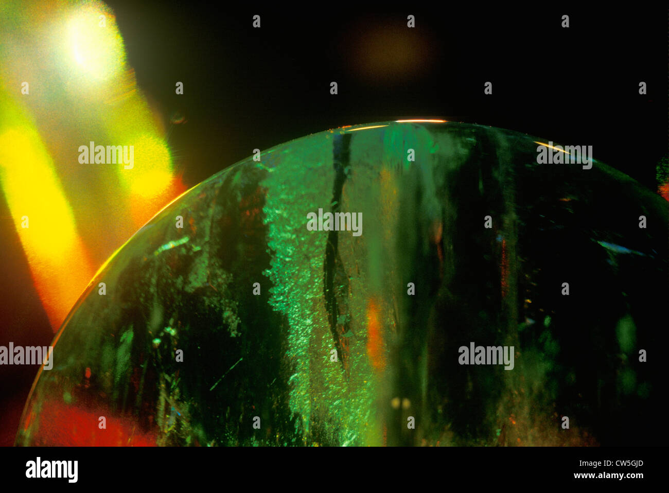 Hands holding a glowing crystal sphere as orange laser light shines ...