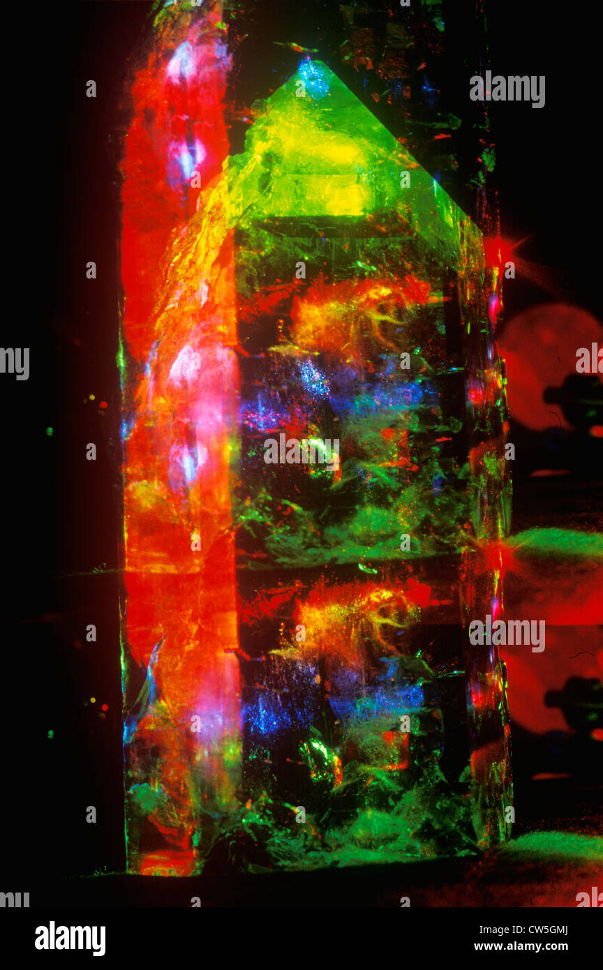 A glowing crystal rock formation illuminated by multicolored laser ...