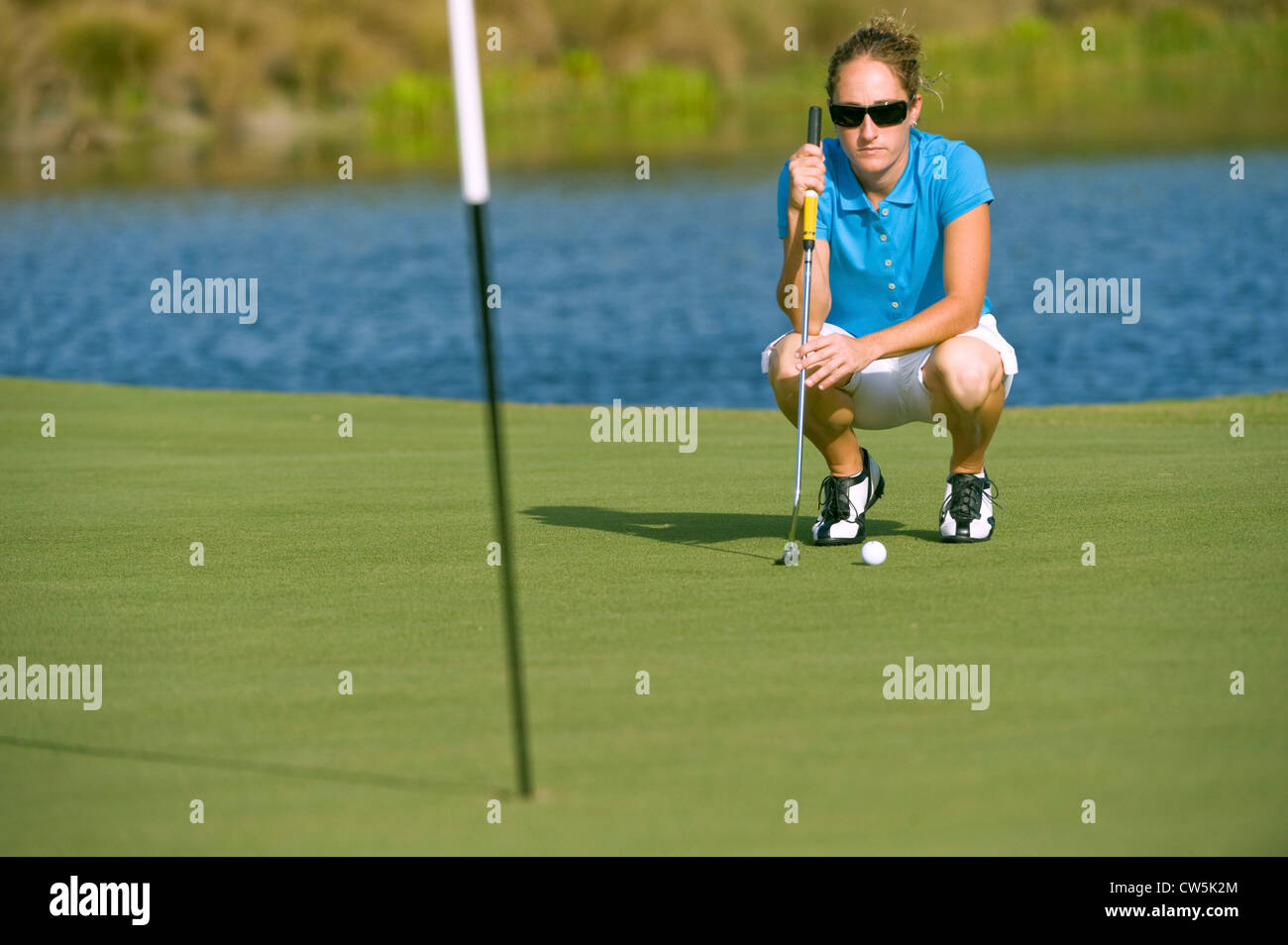 Female golfer putting on green Stock Photo - Alamy