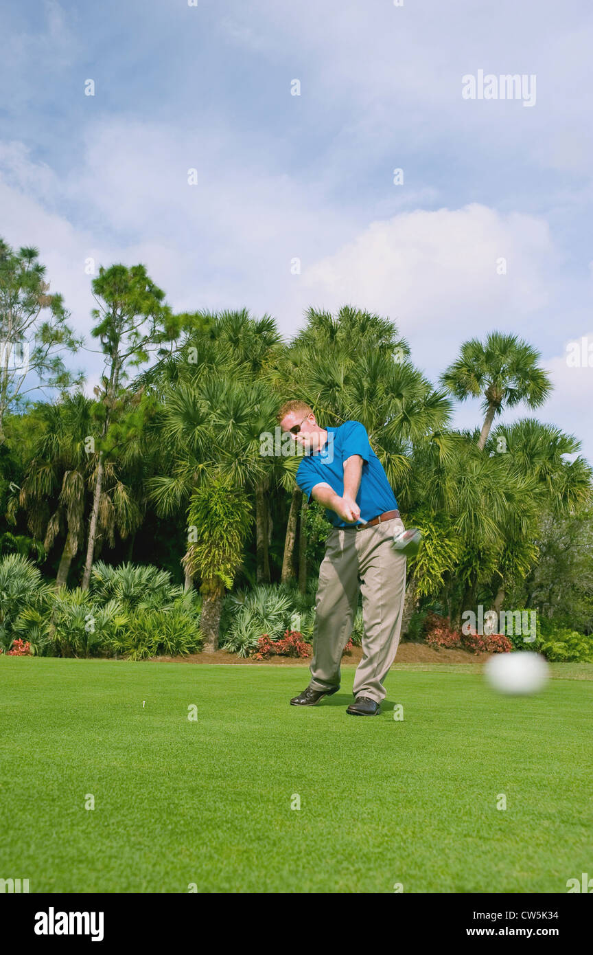 Golfer teeing off with ball in flight Stock Photo - Alamy