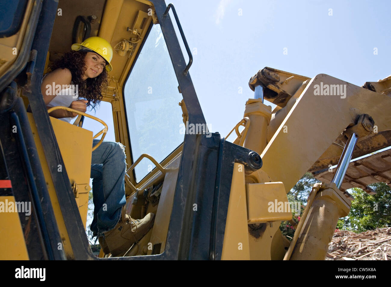 Low angle view of a female construction worker operating a bulldozer ...