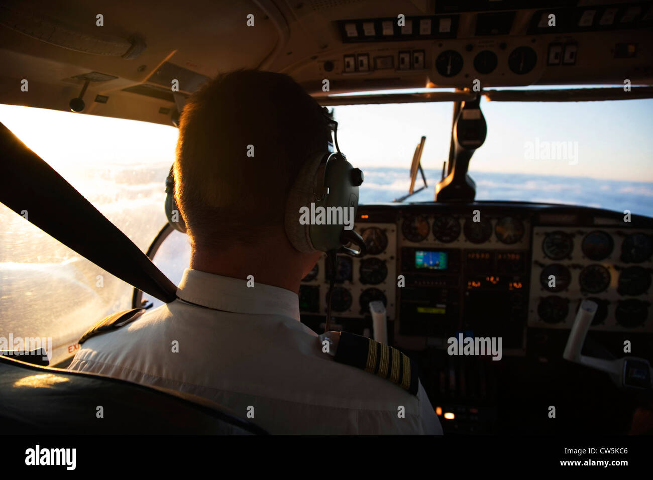 Rear view of a pilot in the cockpit of an aircraft, English Channel ...