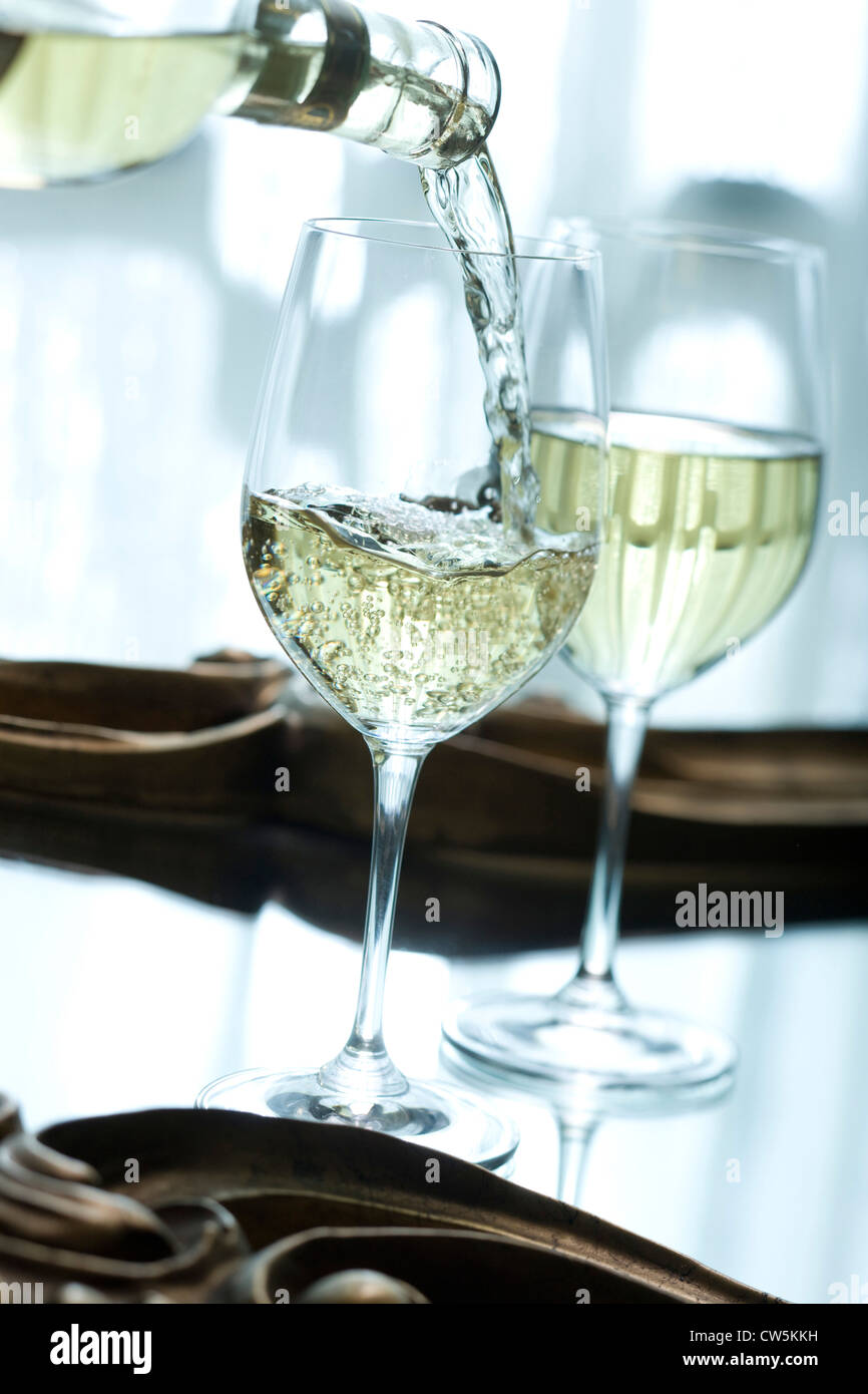 White wine being poured into a wine glass Stock Photo - Alamy