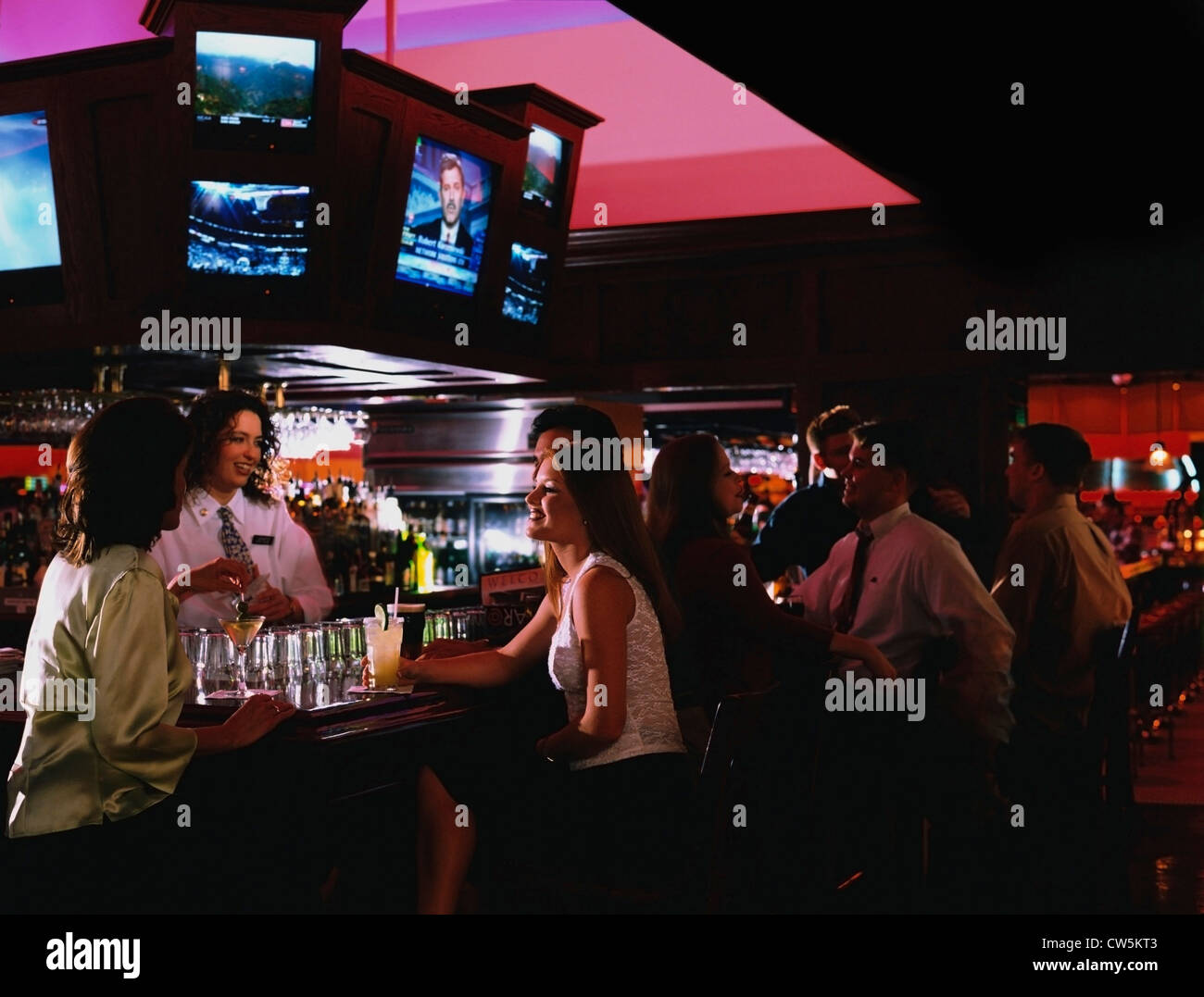 Group of people enjoying drinks in a bar Stock Photo - Alamy