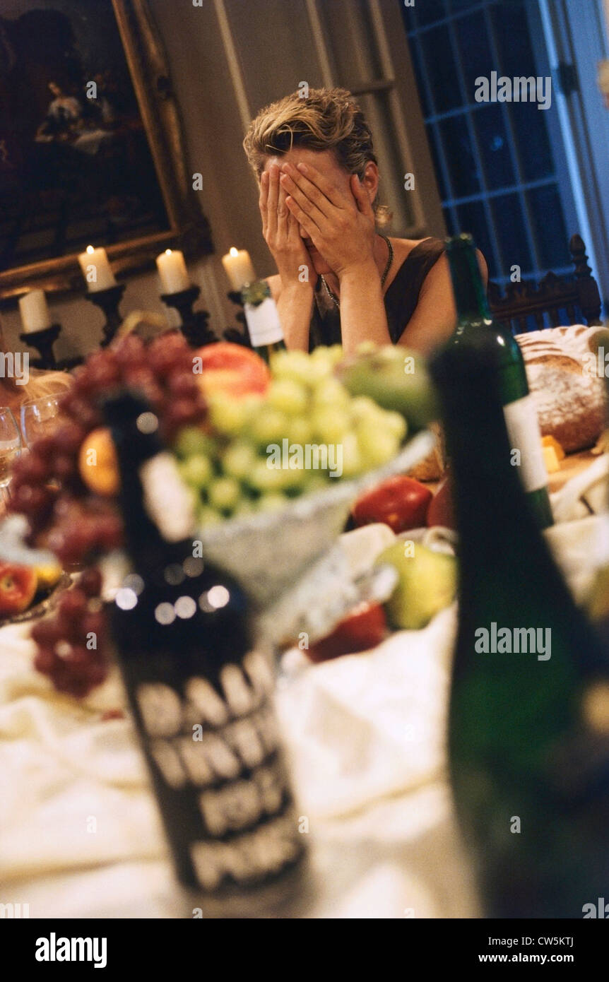 Woman covering her face at a dining table in a dinner party Stock Photo ...