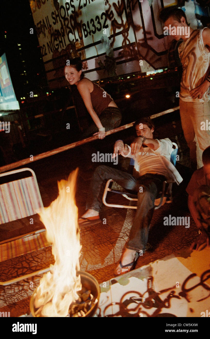 Friends enjoying on a roof around a bonfire Stock Photo - Alamy