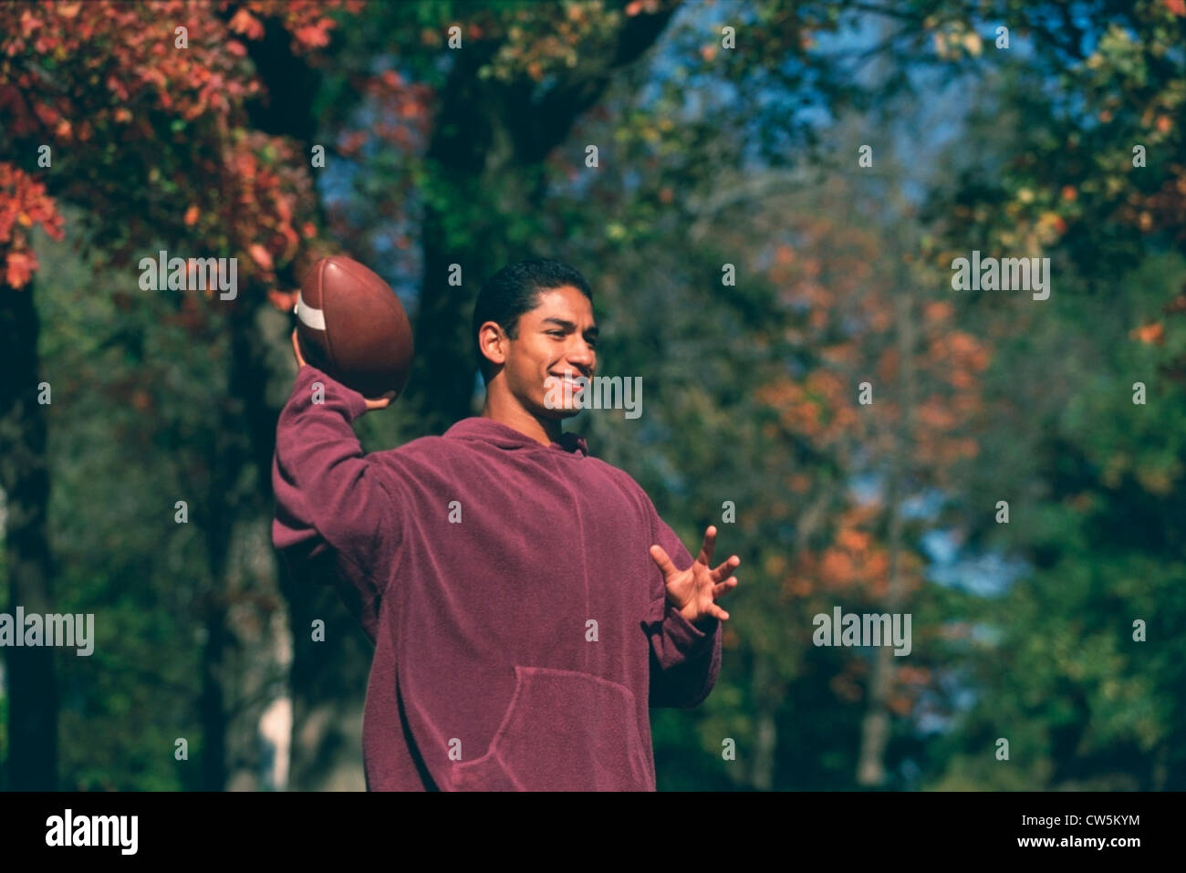 Young man throwing a football in a park Stock Photo - Alamy