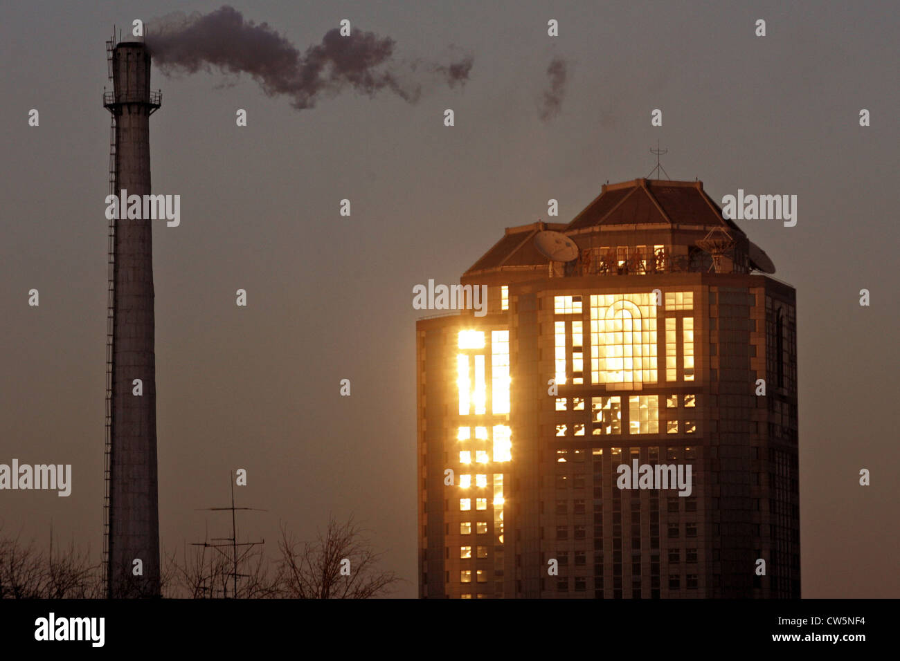 Symbol photo, smoky factory chimney with a shining sun in the house ...