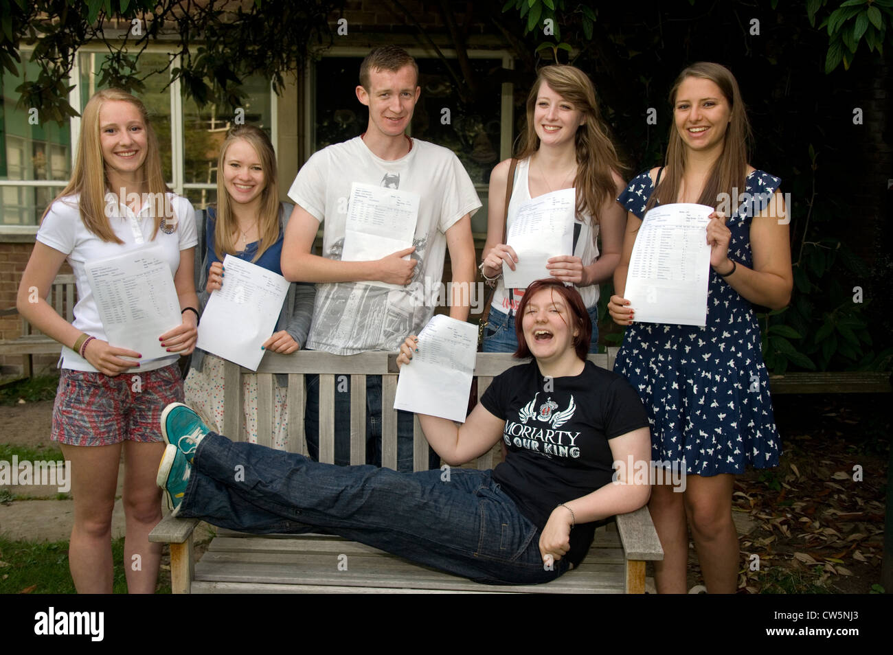 Happy students holding their successful GCSE exam results to camera at ...