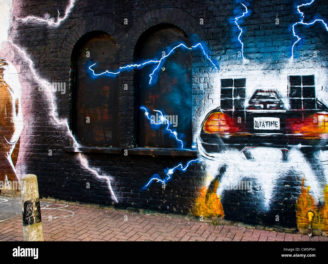 Urban graffiti street art of car and lightning on brick wall in east ...