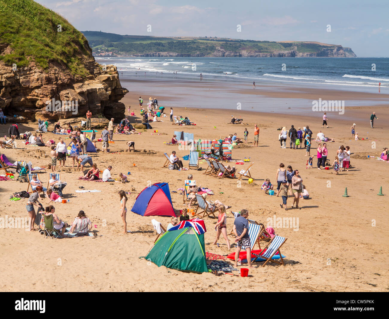 People enjoying Whitby Sands Yorkshire UK in summer Stock Photo - Alamy