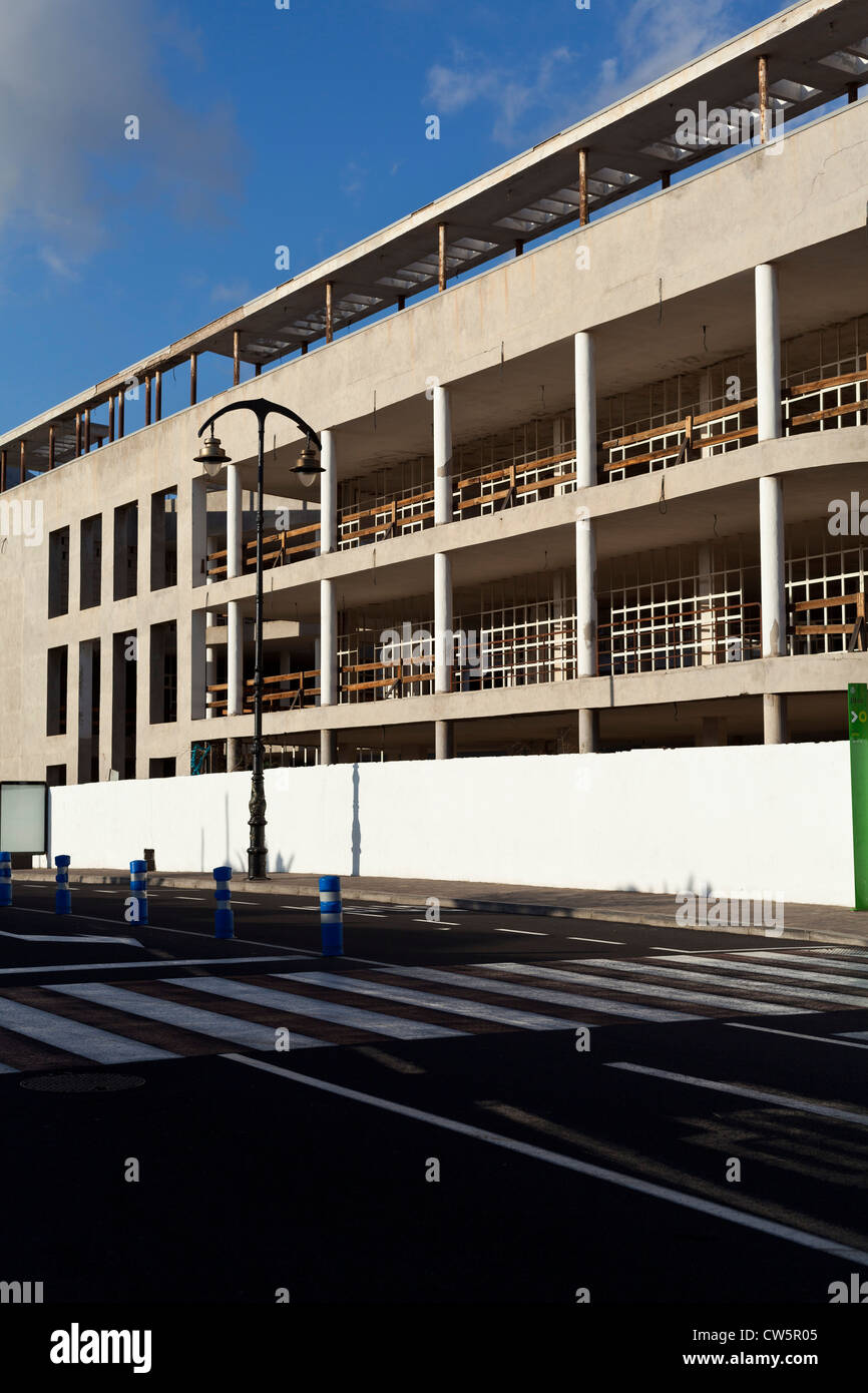 An unfinished building lies empty and walled off on the west coast of ...