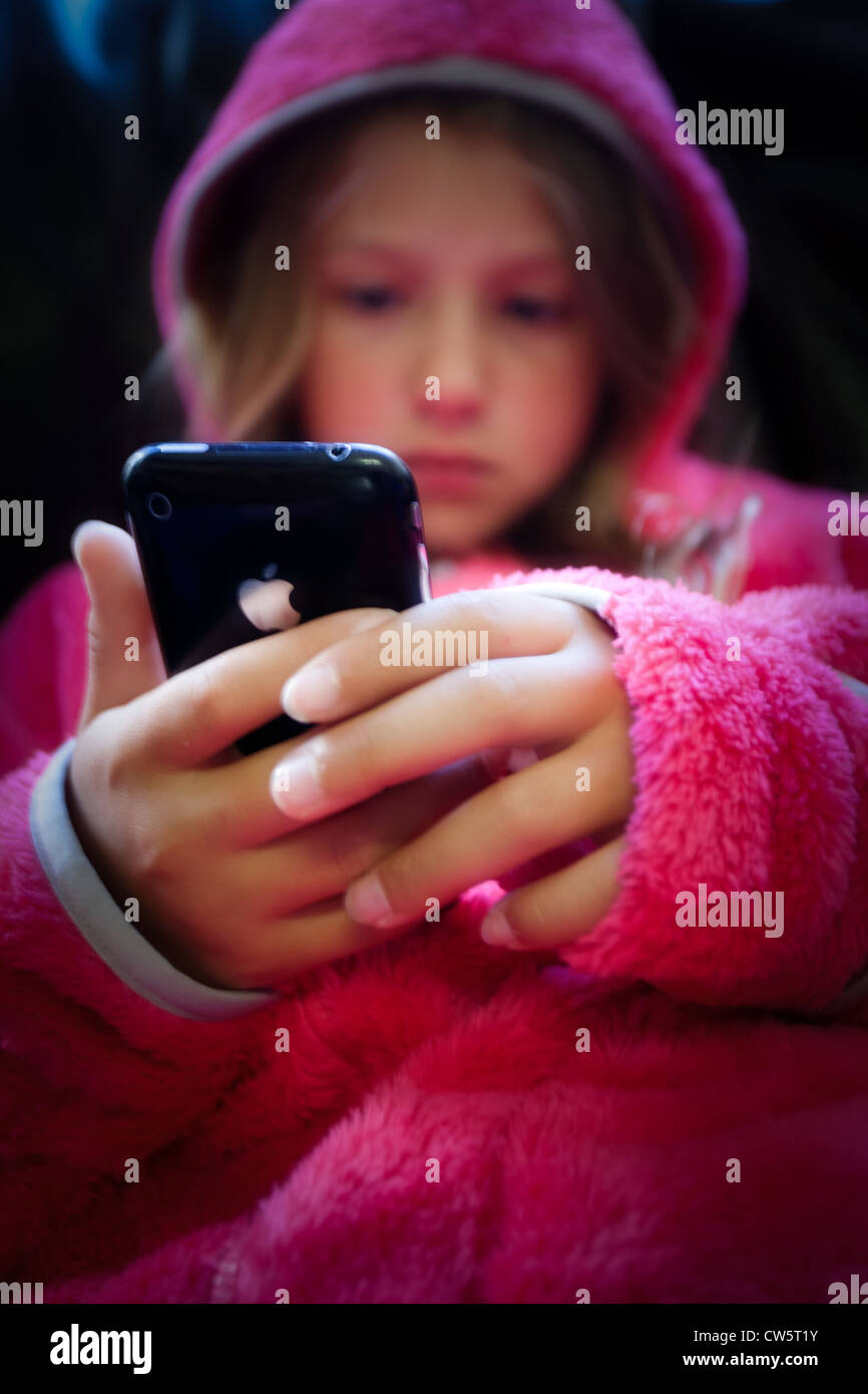 A young girl in a pink hoody looking at a Apple iPhone Stock Photo - Alamy