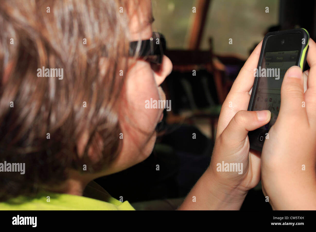 An eleven year old girl texting text her father on an Apple IPod touch ...